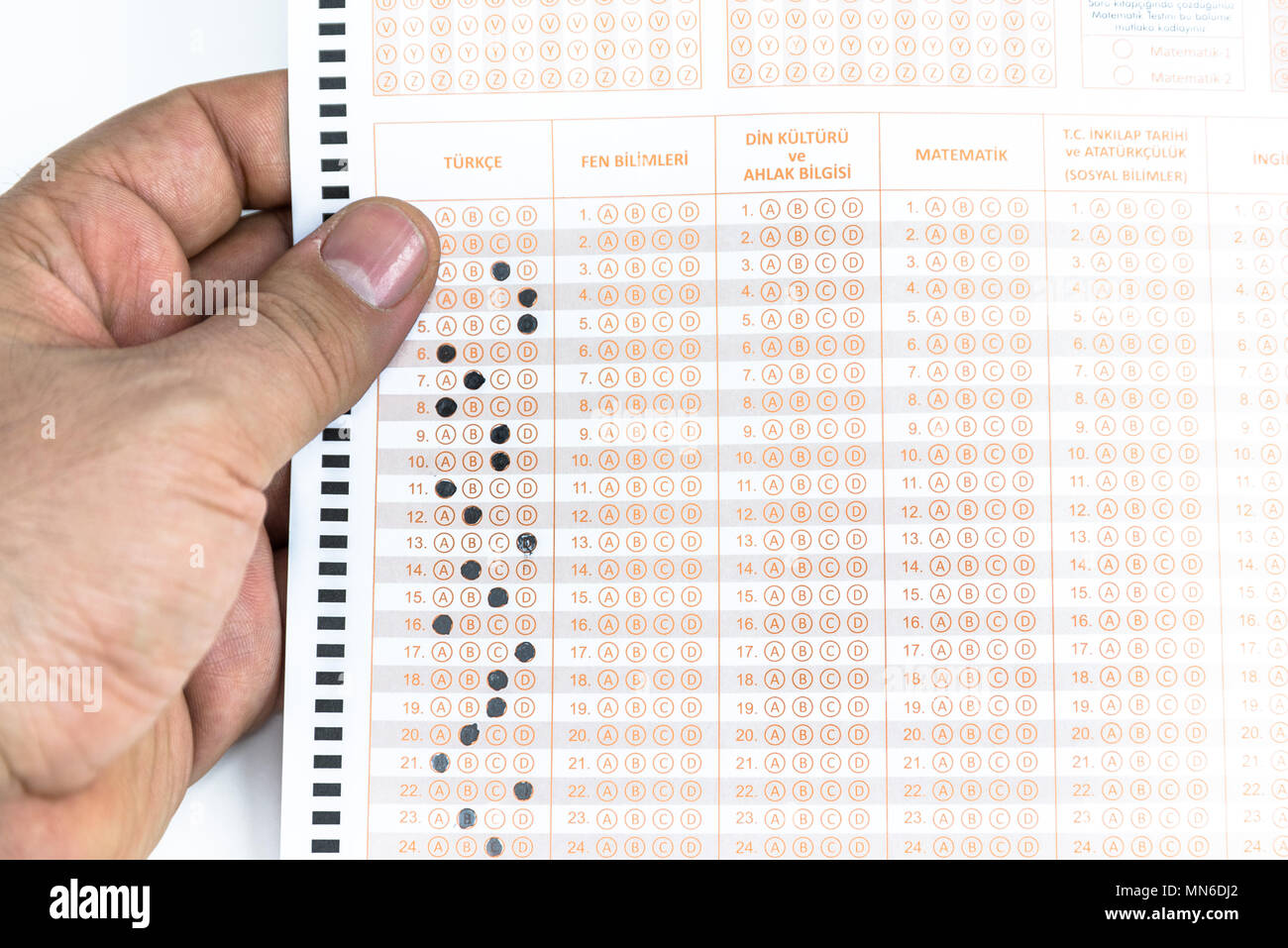 Man hand holds marked ,filled out answer test score sheet with answers ...