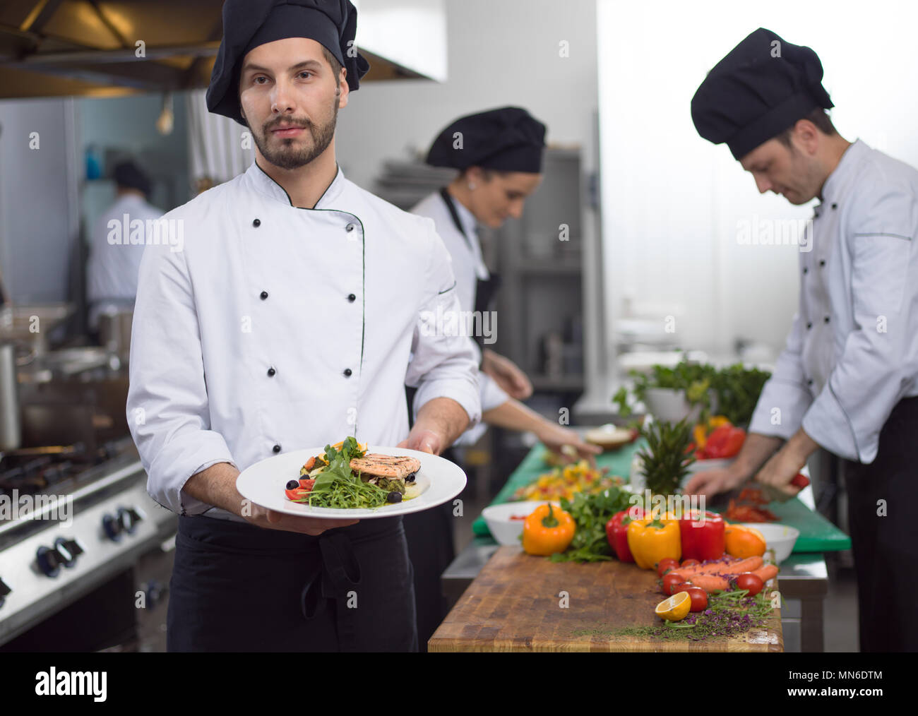 Chef holding fried Salmon fish fillet with vegetables for dinner in a ...