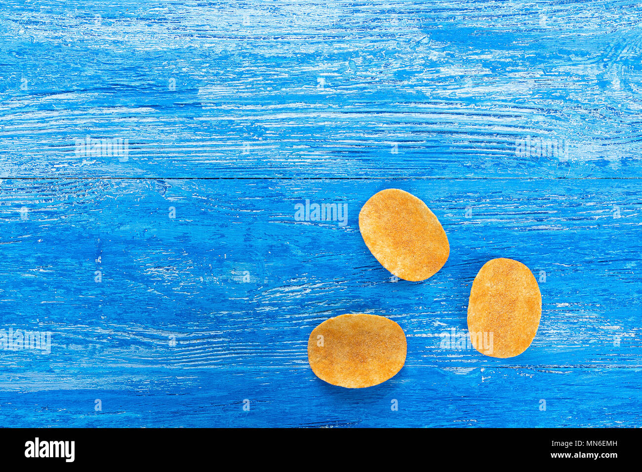 potato chips on a blue wooden background, cold snack, unhealthy eating ...