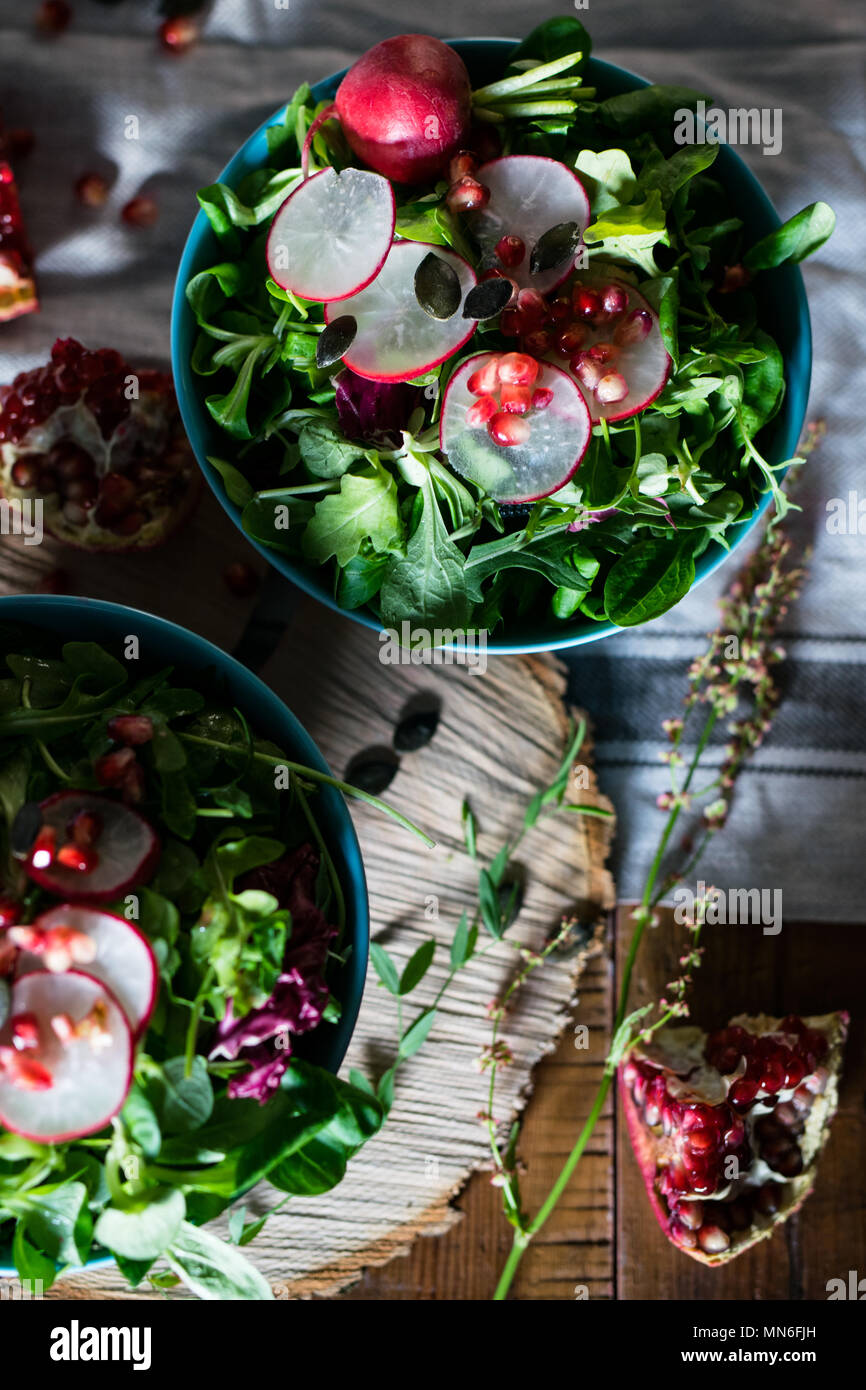 Rustic salad with leafy greens, radish and pomegranate Stock Photo - Alamy