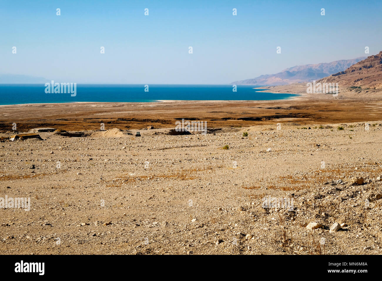 Dead sea shore with blue water and rock salt on background Stock Photo ...