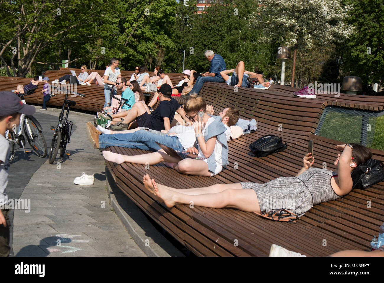 Moscow, RUSSIA - MAY 5, 2018: People sunbathe on a park bench Stock ...