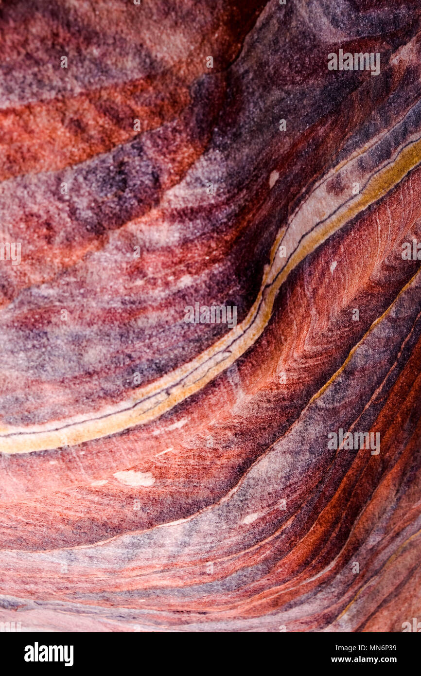 Colorful sandstone wall eroded in a design in Petra World Heritage site ...