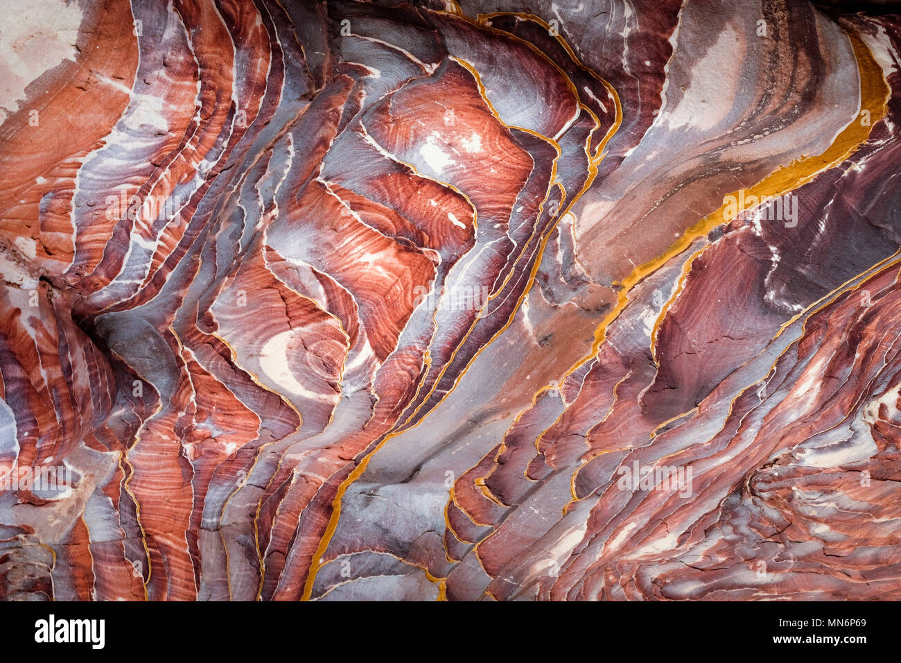 Colorful sandstone wall eroded in a design in Petra World Heritage site ...