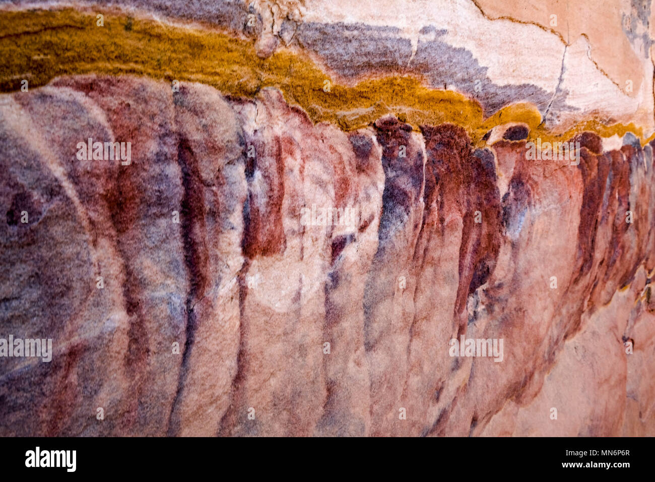 Colorful sandstone wall eroded in a design in Petra World Heritage site ...