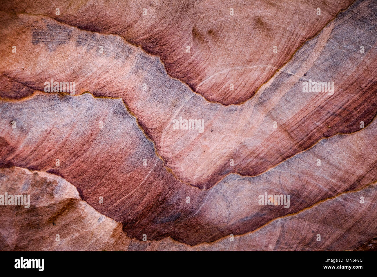 Colorful sandstone wall eroded in a design in Petra World Heritage site ...