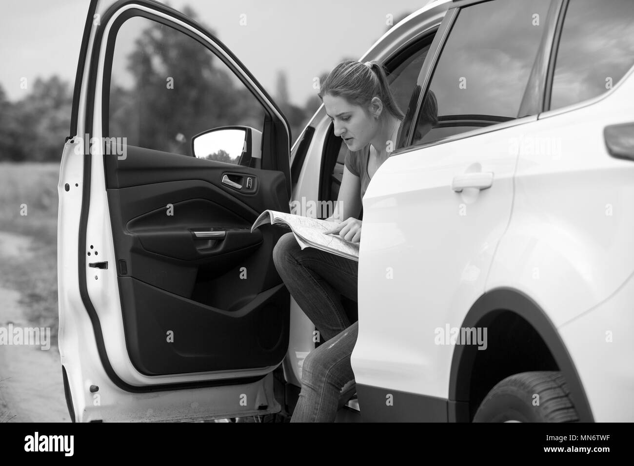 Black and white portrait of young woman got lost on the countryside ...