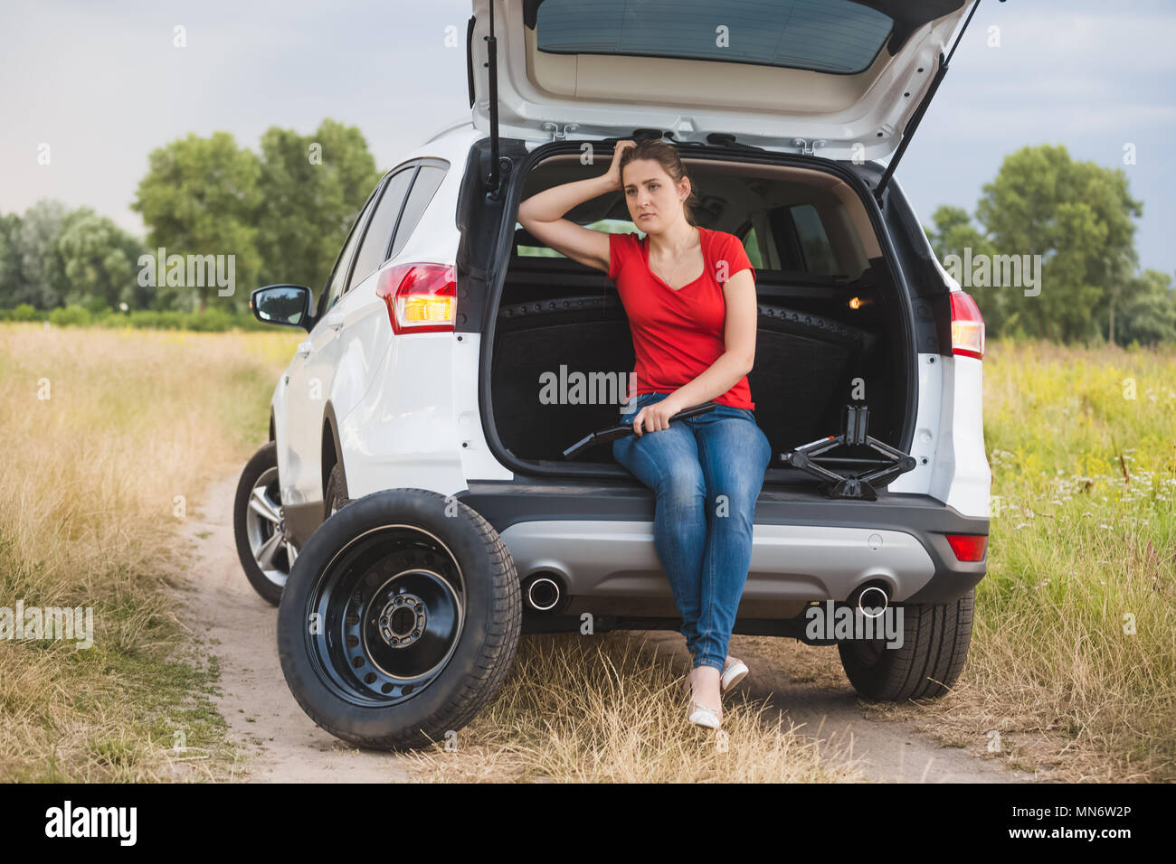 Car woman changing flat tire hi-res stock photography and images - Alamy