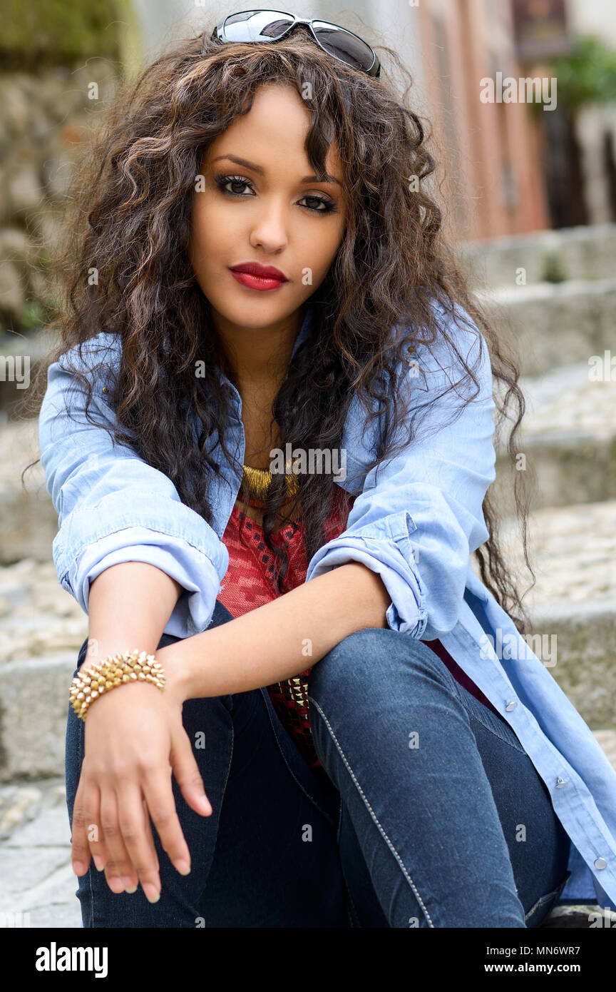 Portrait of attractive mixed woman in urban background wearing casual ...