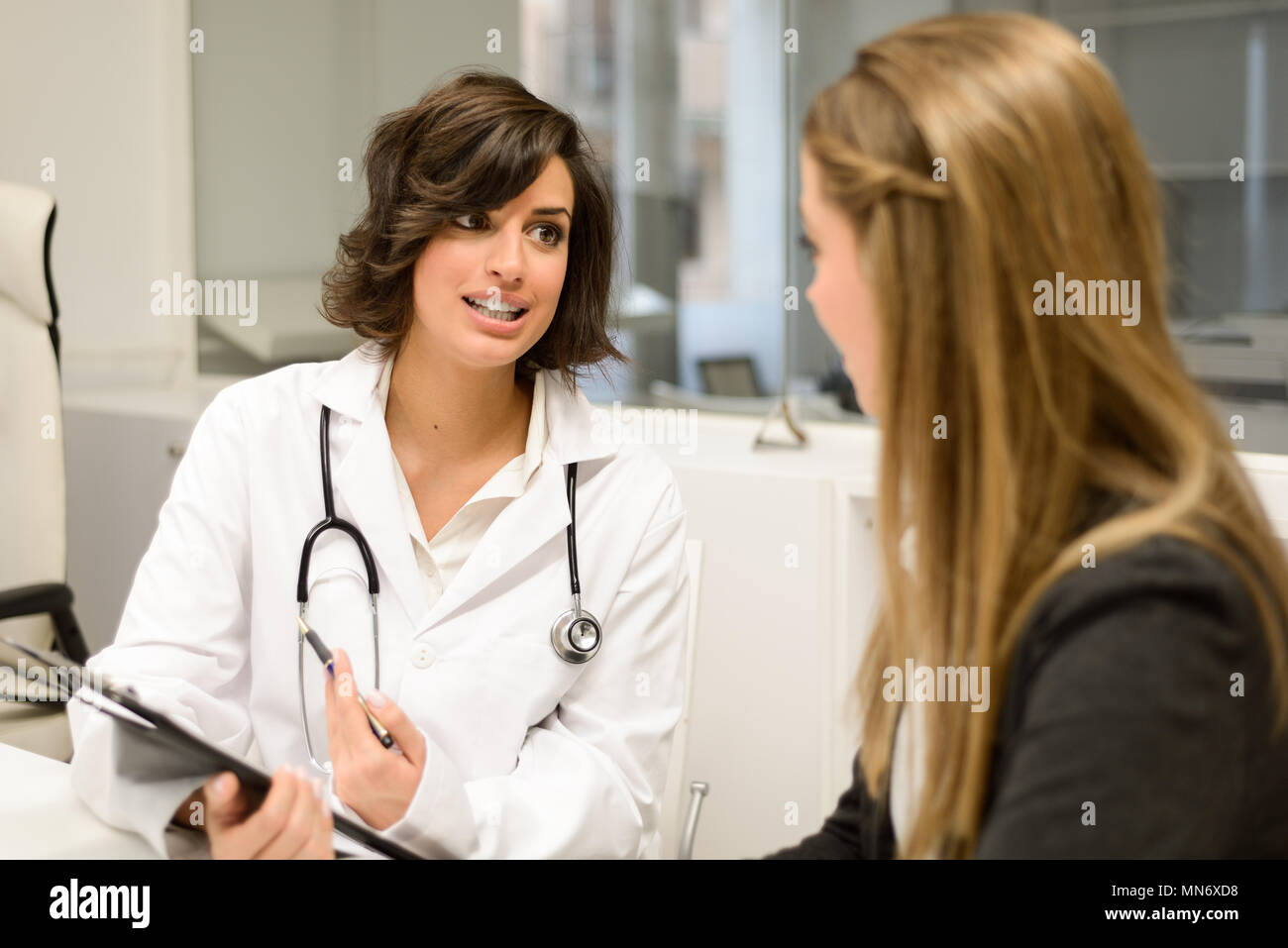 Female doctor explaining diagnosis to her female patient Stock Photo ...