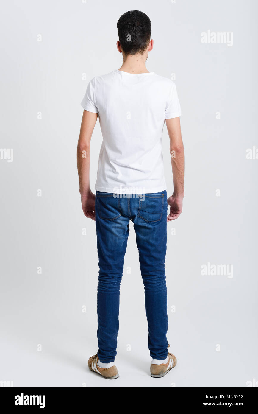 Portrait of a smart serious young man standing against white background ...