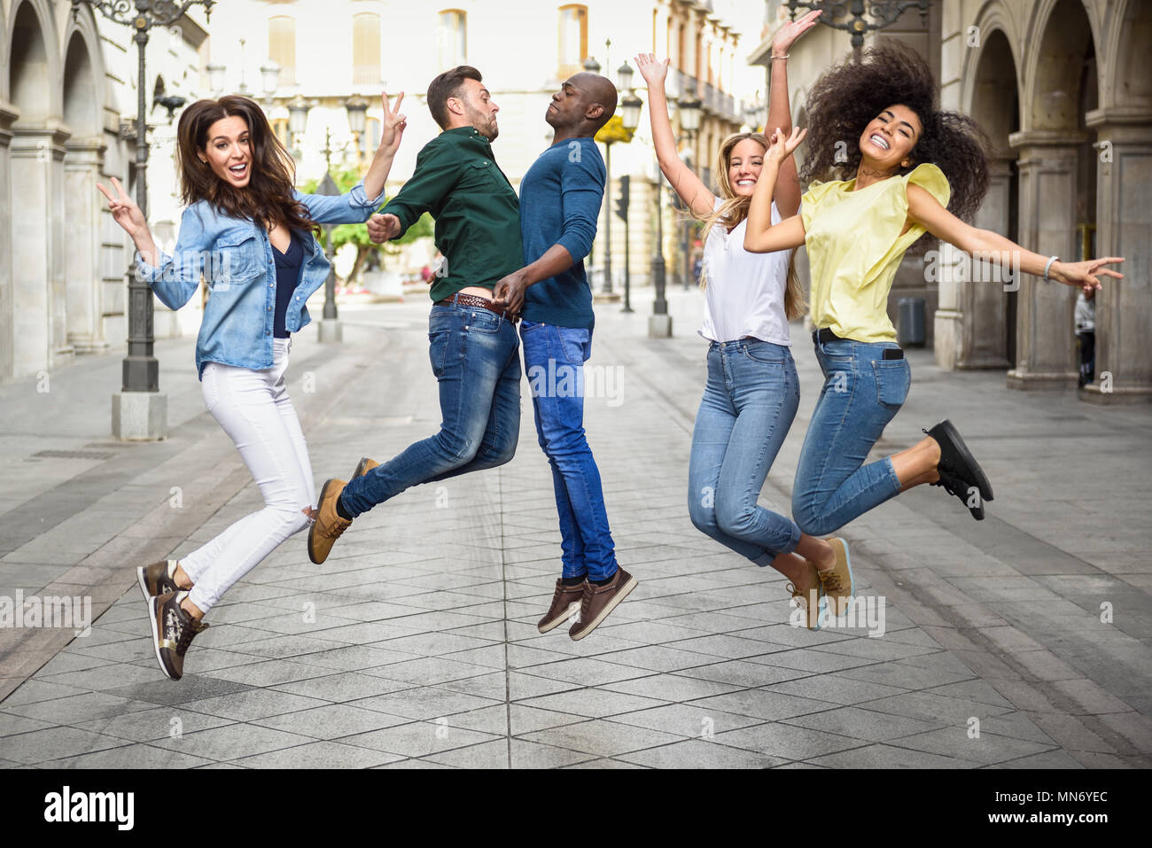 Multi-ethnic group of young people having fun together outdoors in ...