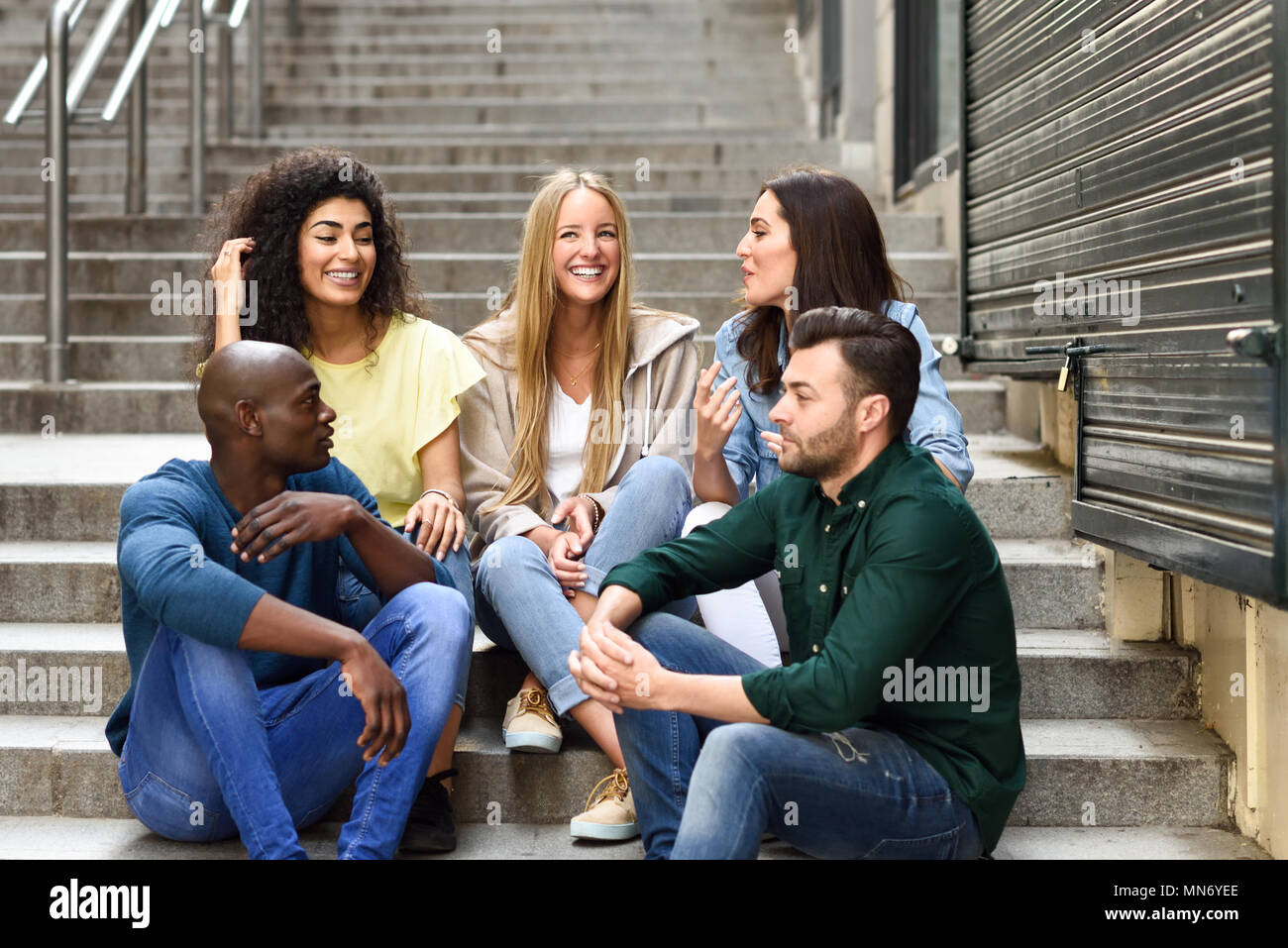 Multi-ethnic group of young people having fun together outdoors in ...