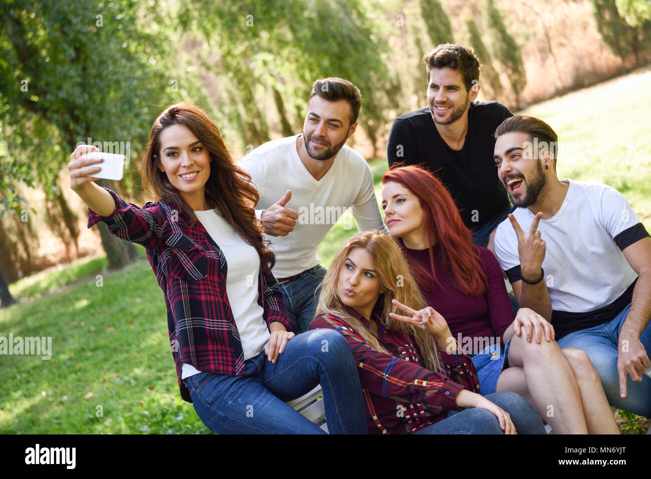 Group of friends taking selfie in urban park. Five young people wearing ...