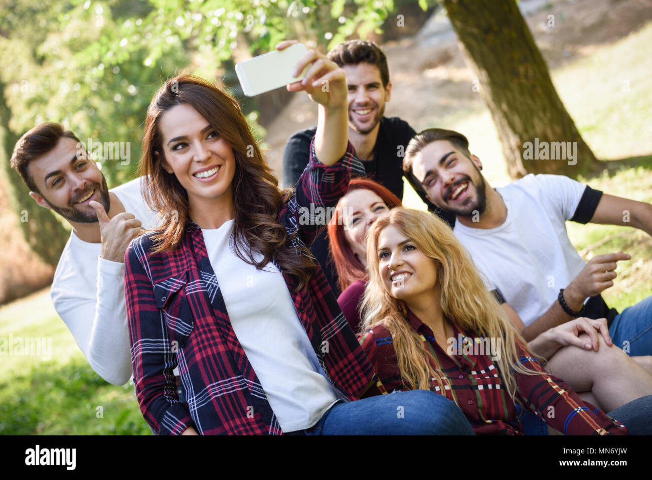 Group of friends taking selfie in urban park. Five young people wearing ...