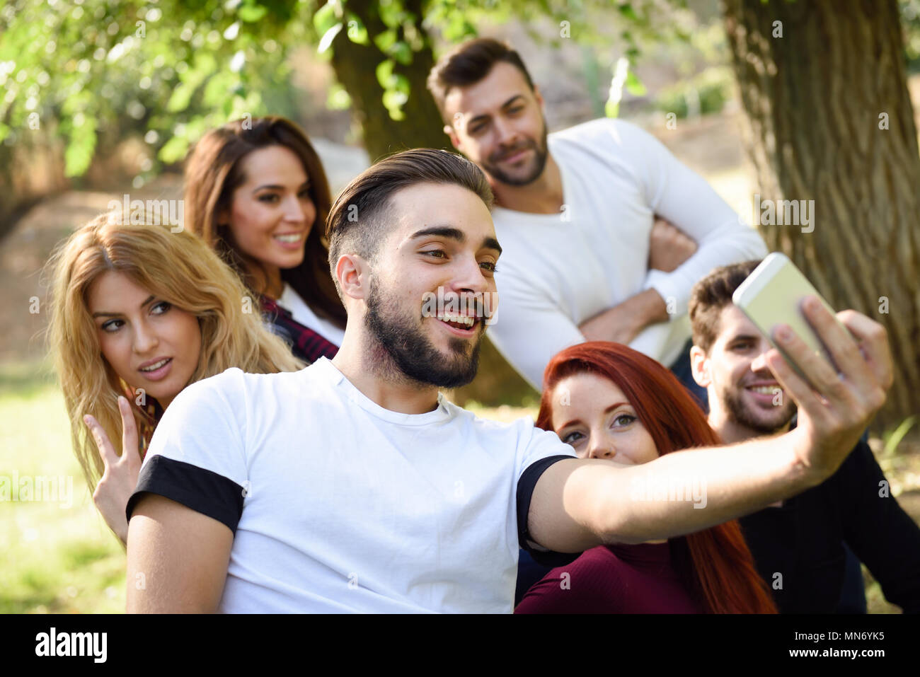 Group of friends taking selfie in urban park. Five young people wearing ...