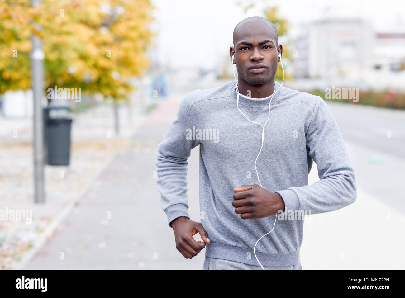 Attractive black man running in urban background. Male doing workout ...