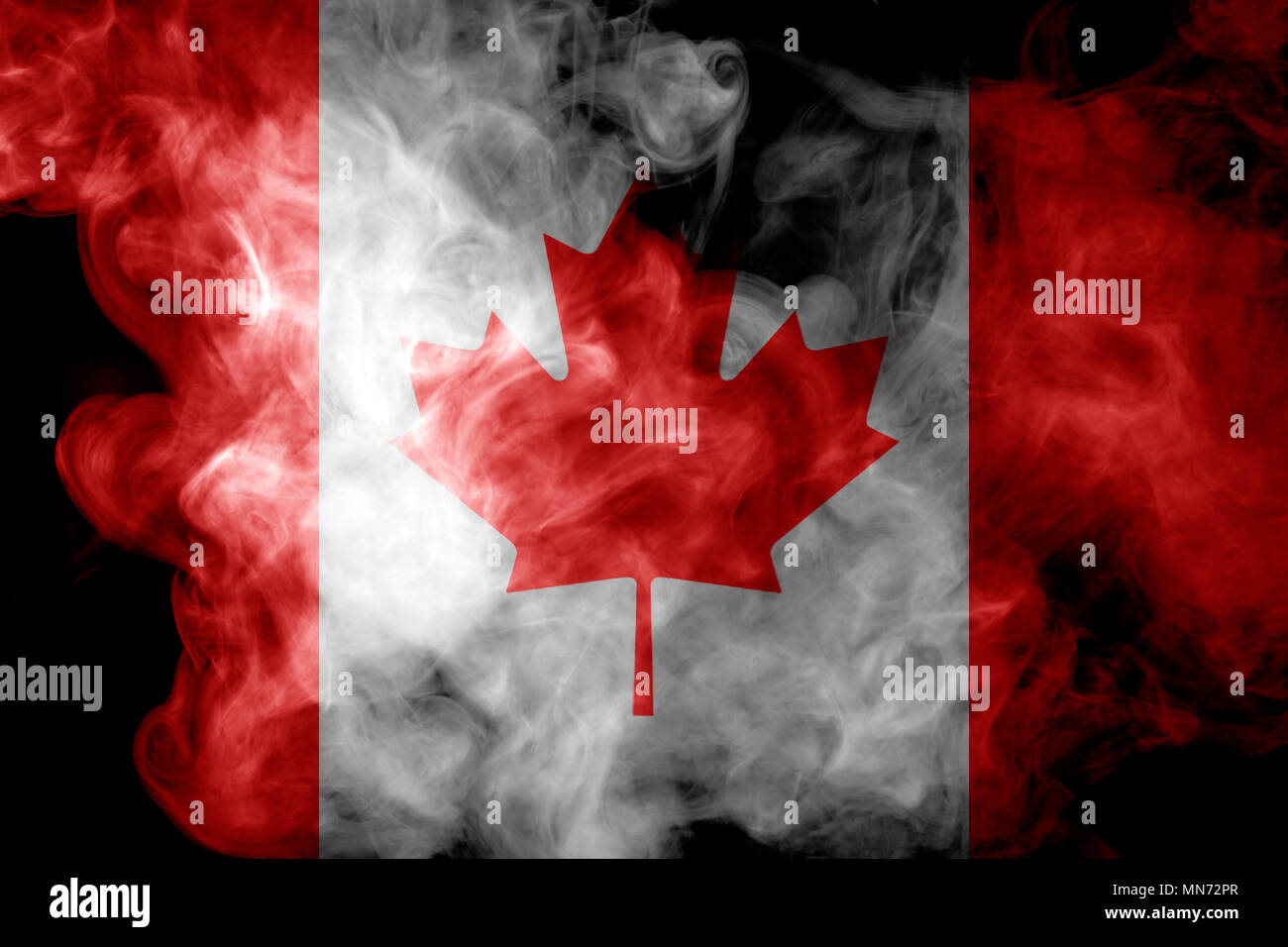 National flag of Canada from thick colored smoke on a black isolated ...