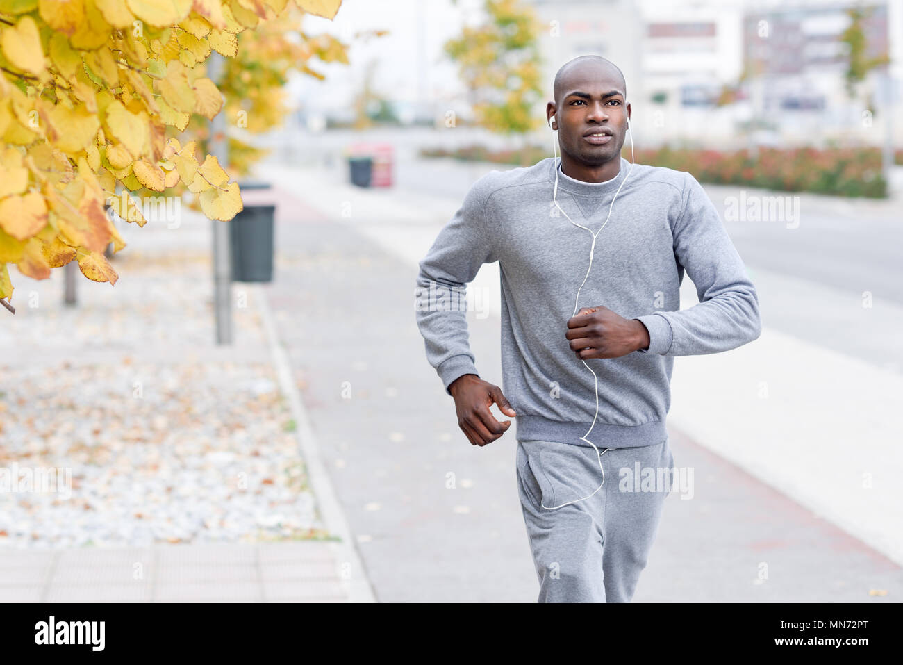 Attractive black man running in urban background. Male doing workout ...