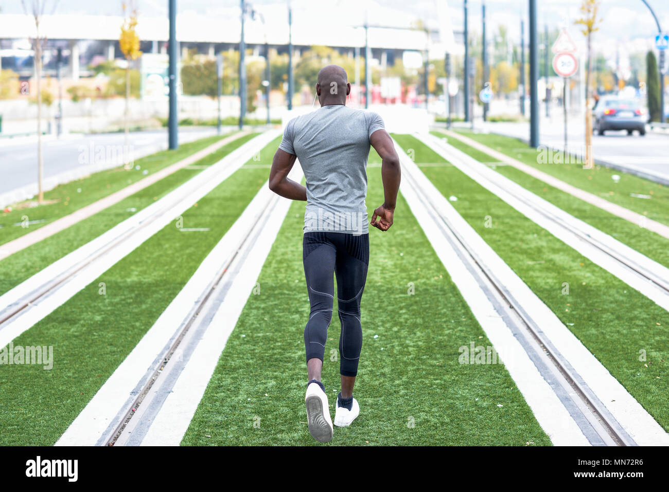 Back view of black man running in urban background. Male doing workout ...