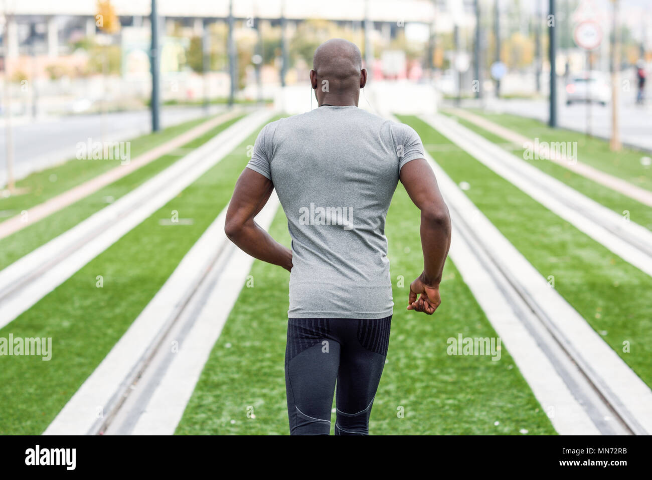 Back view of black man running in urban background. Male doing workout ...