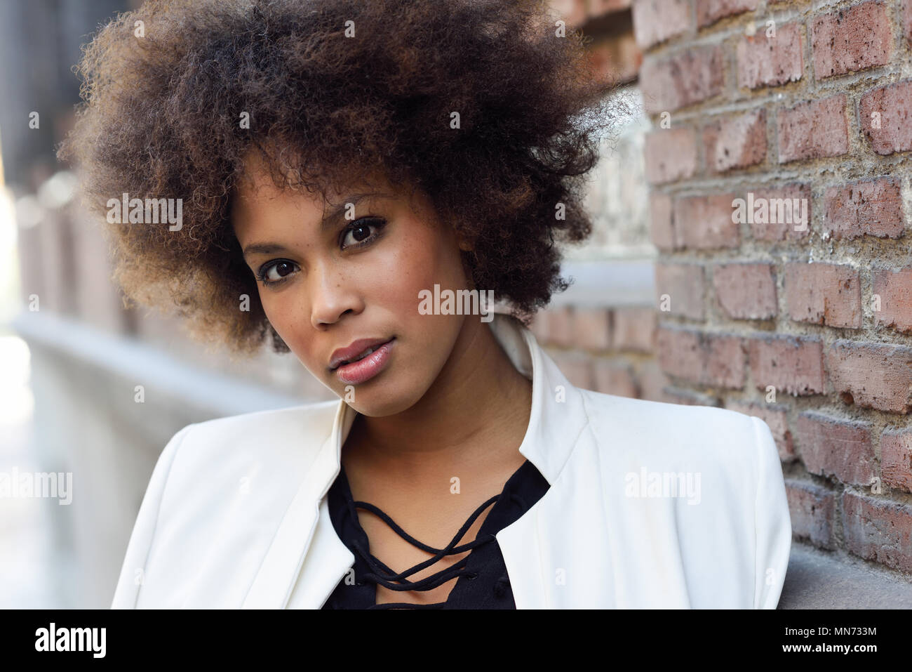 Close Up Portrait Of Black Woman With Afro Hairstyle Standing In Urban