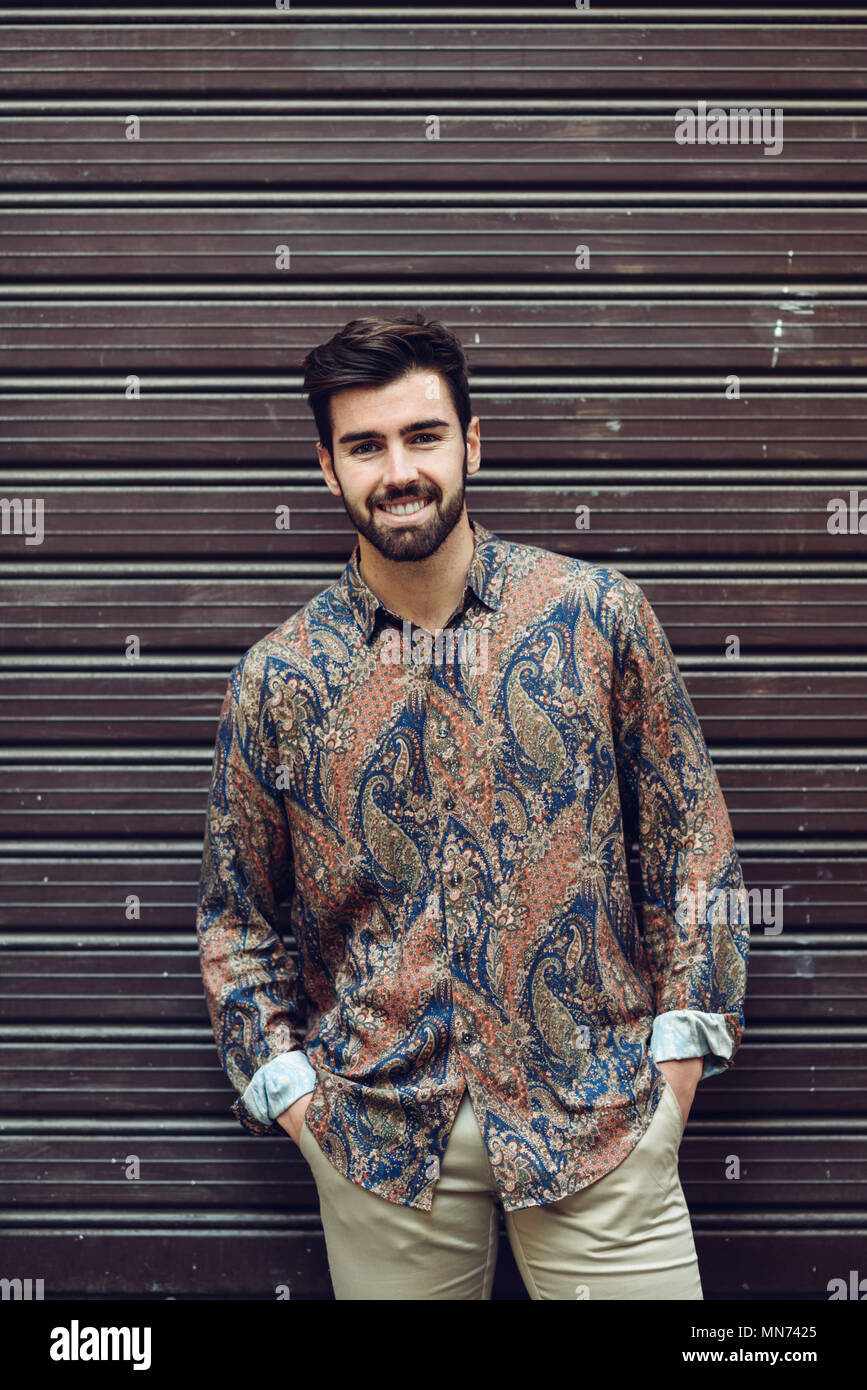 Young smiling man, model of fashion, wearing modern shirt in the street ...