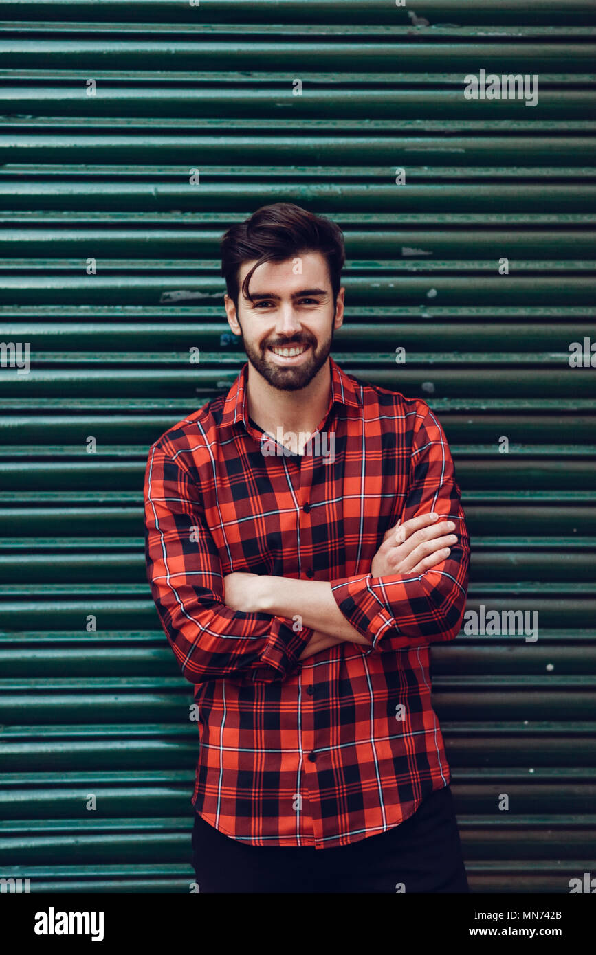 Young bearded man, model of fashion, wearing a plaid shirt with a green ...