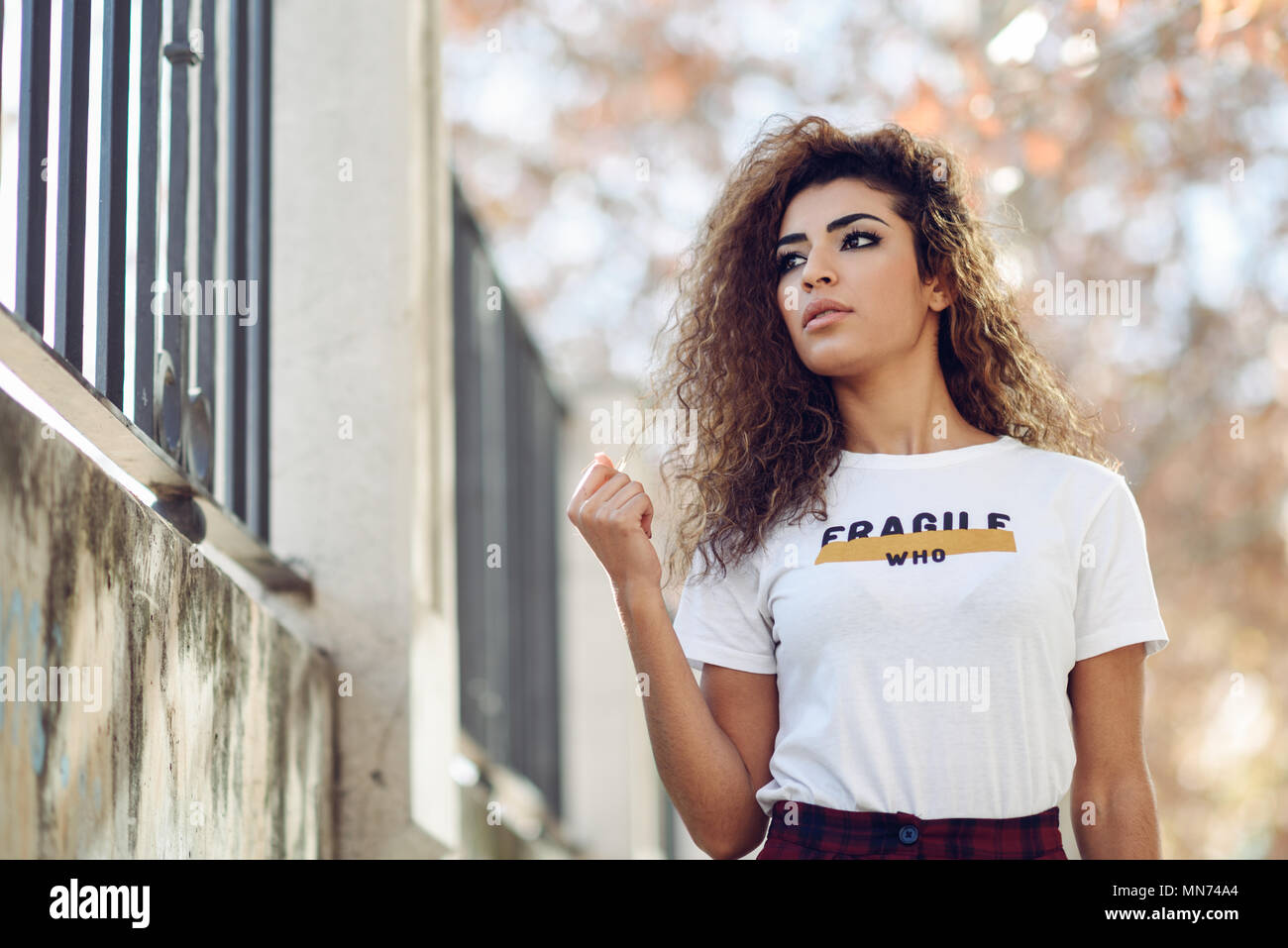 Beautiful young arabic woman with black curly hairstyle. Arab girl in casual clothes in the ...