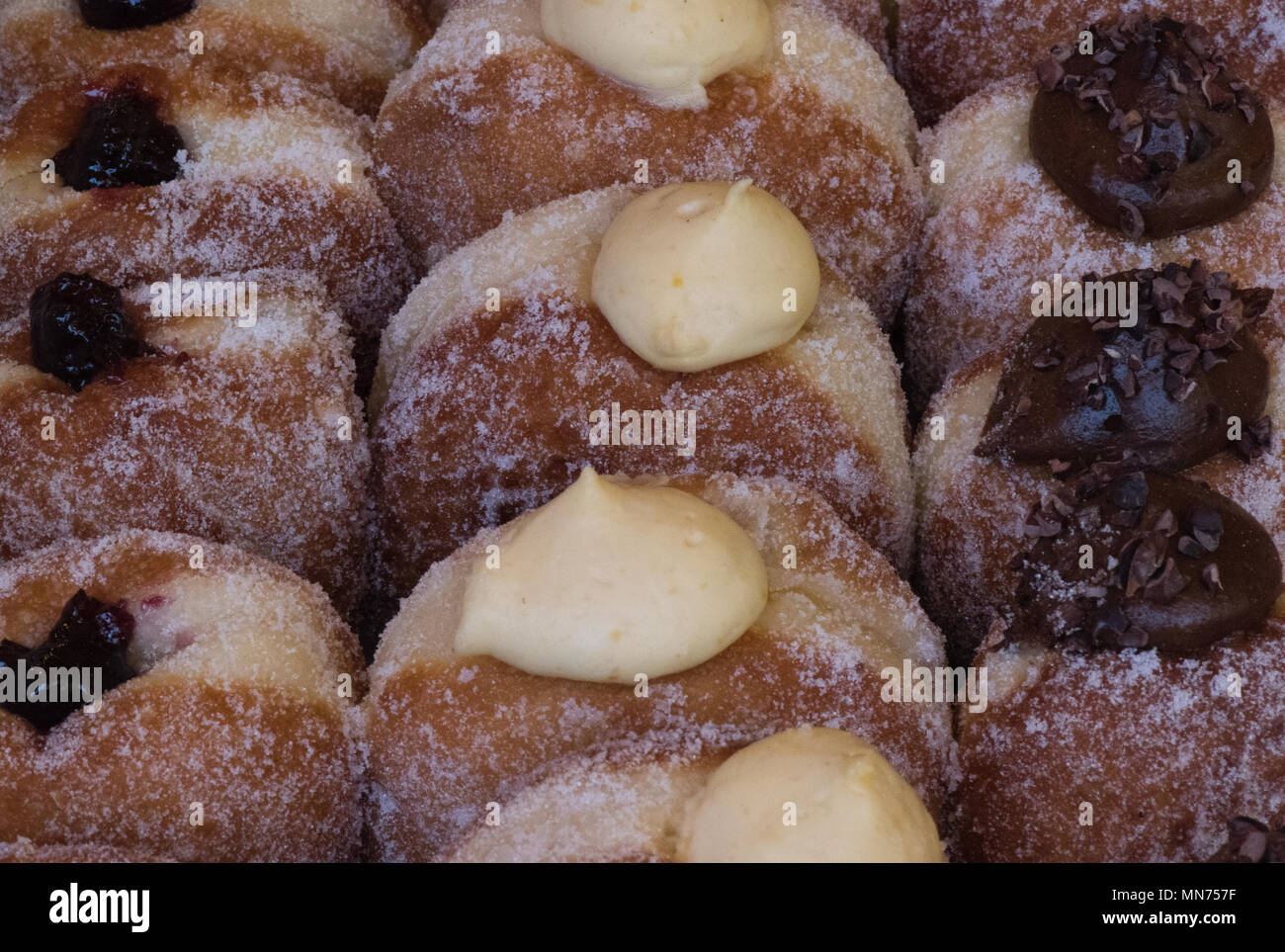 Rows of sugar red donuts on display on stall at borough market in ...