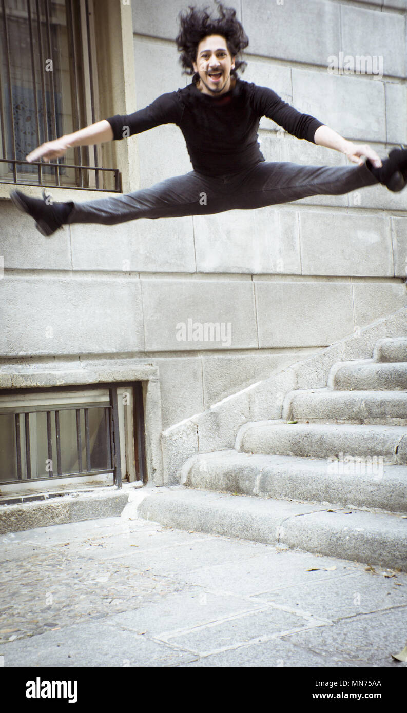 Male dancer performing jump in the air. Urban background Stock Photo ...