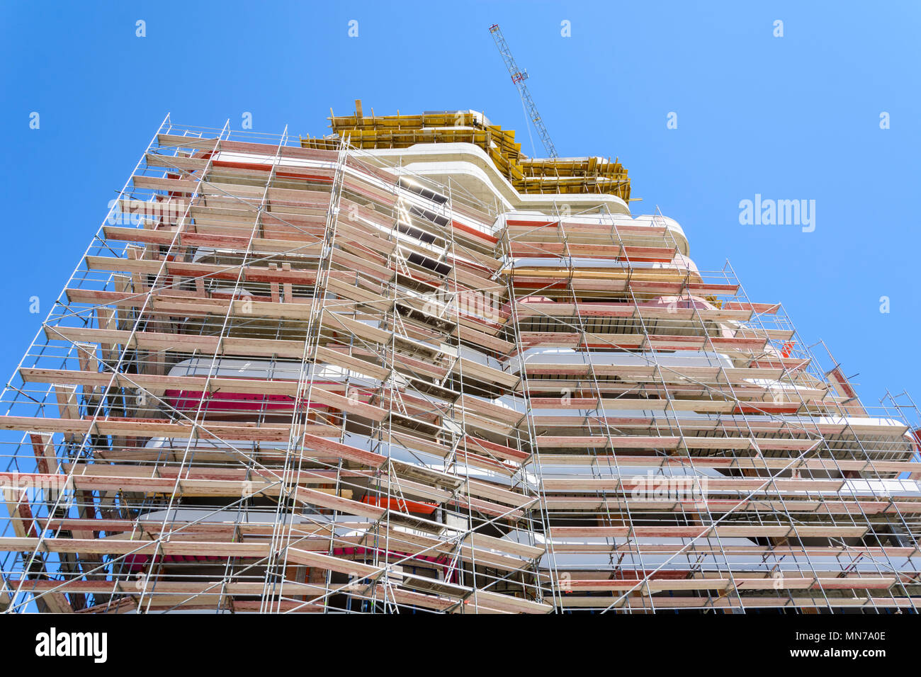 tall Building in construction with scaffolding on blue sky Stock Photo ...