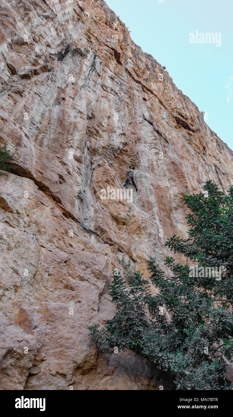 Male climber hanging by a cliff Stock Photo - Alamy