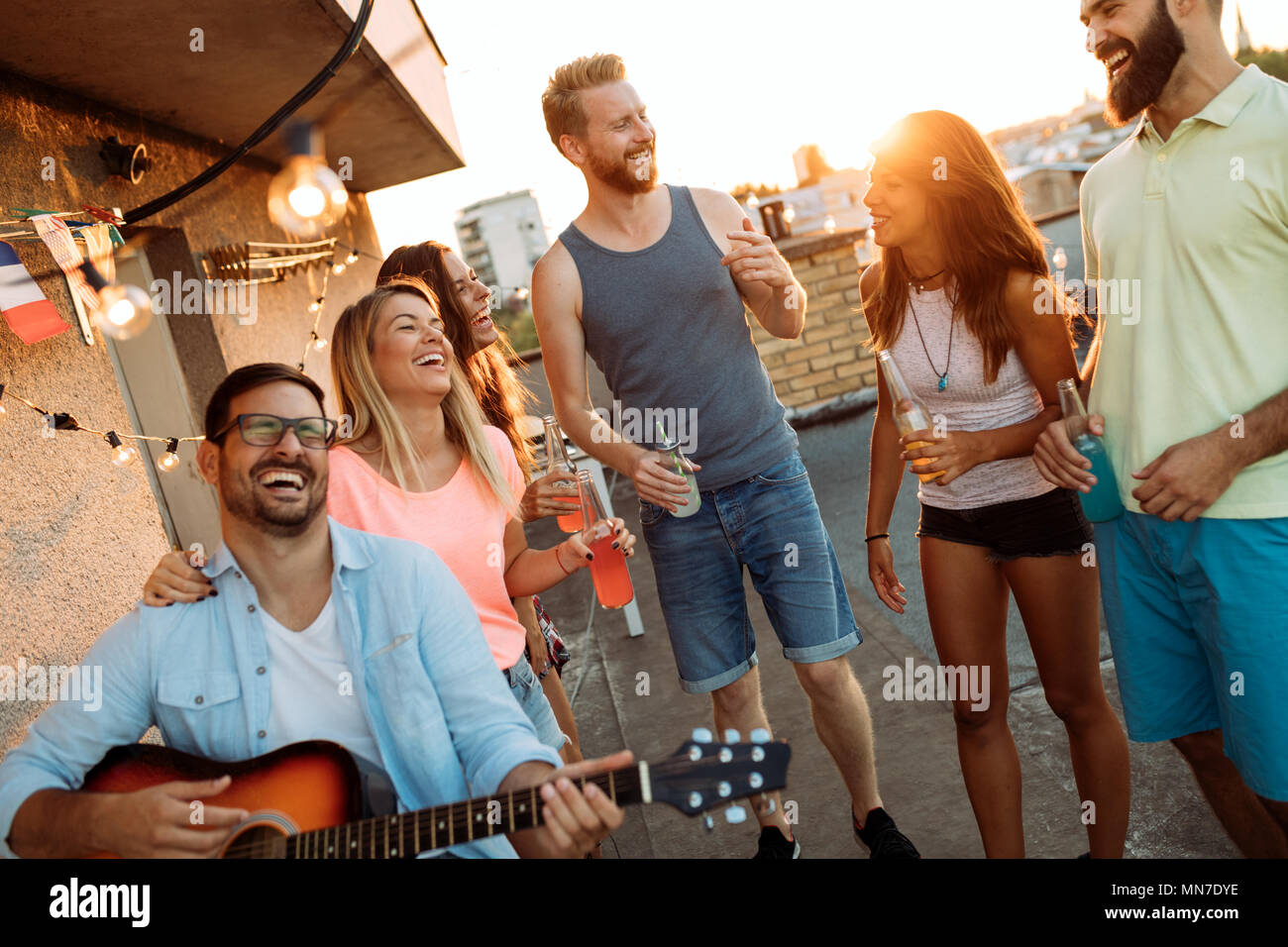 Group of happy friends having party on rooftop Stock Photo - Alamy