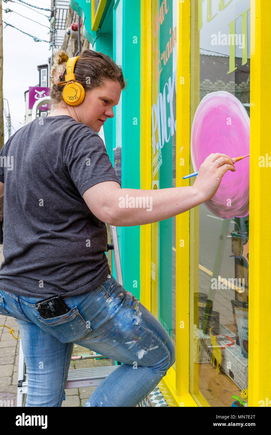 Female sign writer painting a shop window, Cahersiveen, County Kerry ...