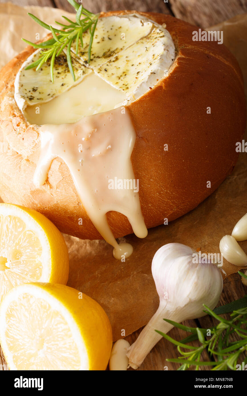 melted camembert in a loaf of bread close-up on a table. vertical Stock ...