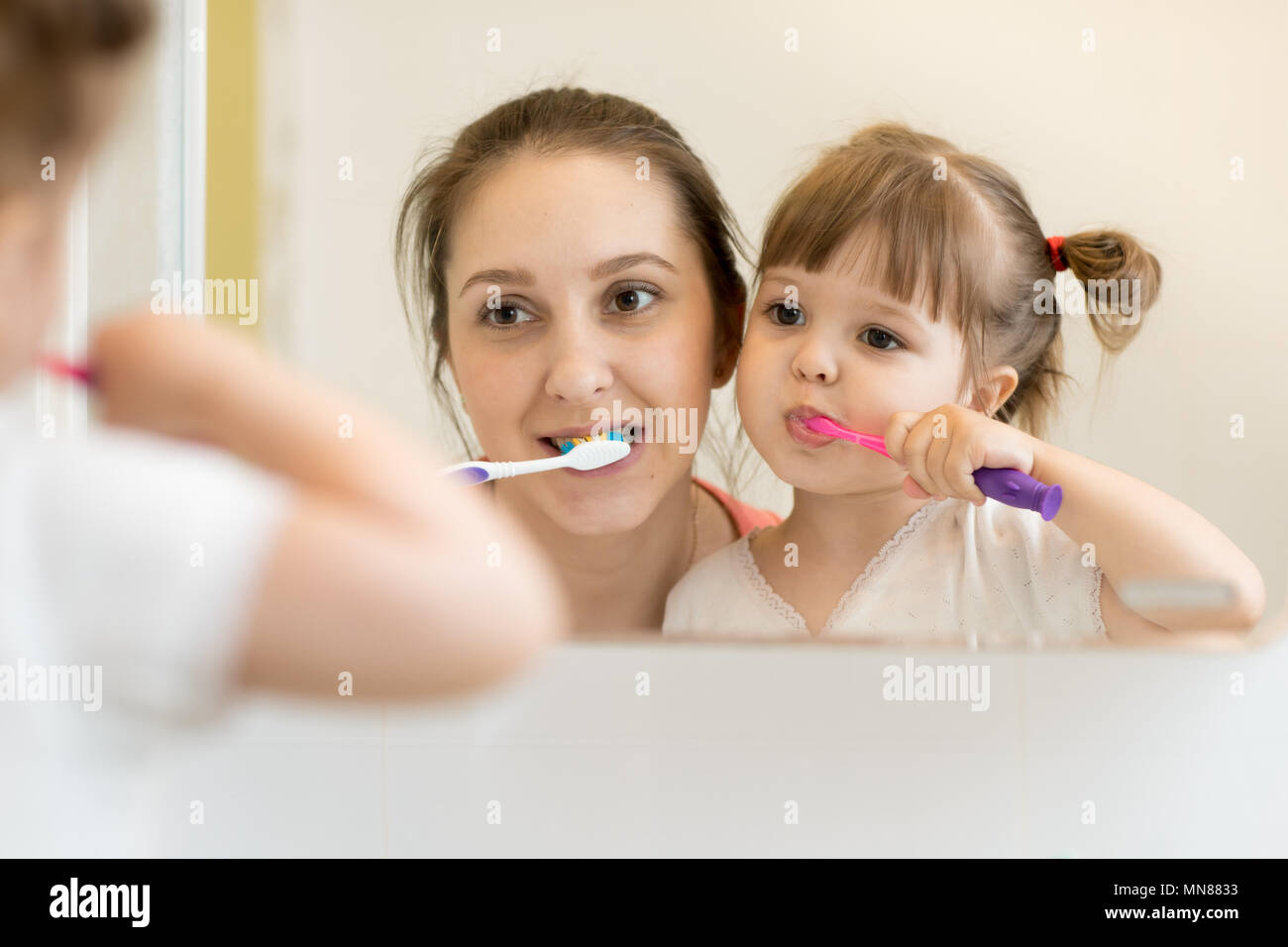mother teaching child daughter teeth brushing Stock Photo - Alamy