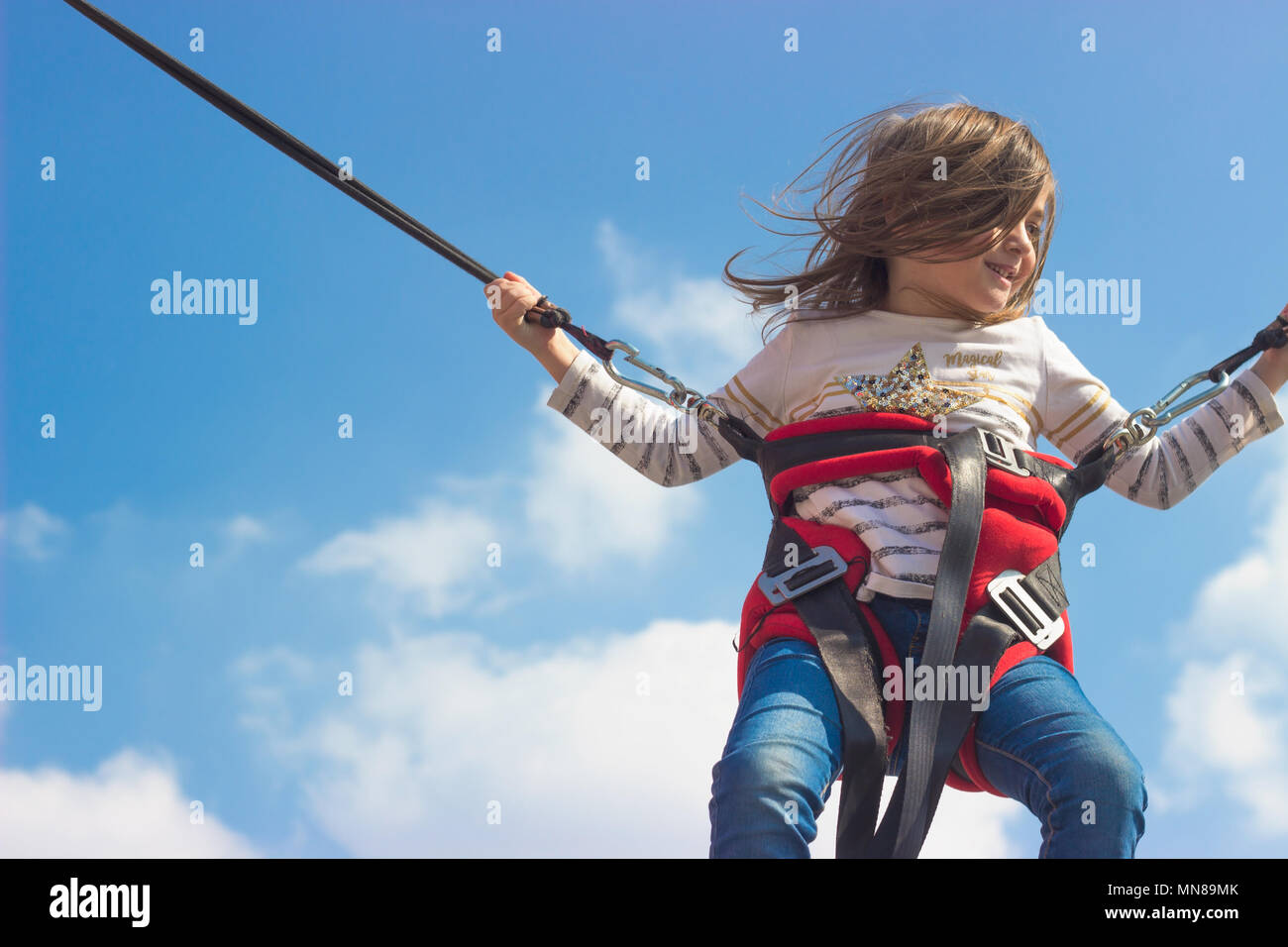 Little girl jumping on trampoline Stock Photo - Alamy