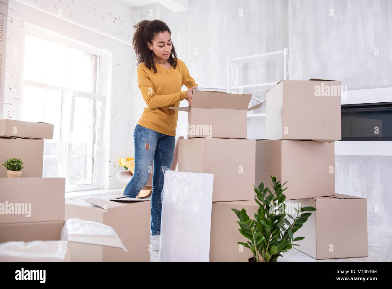 Charming young student packing belongings before moving out Stock Photo ...