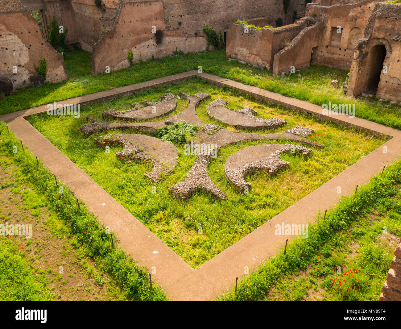 view on ruine of an old fountain with green lawn in the center of Rome ...