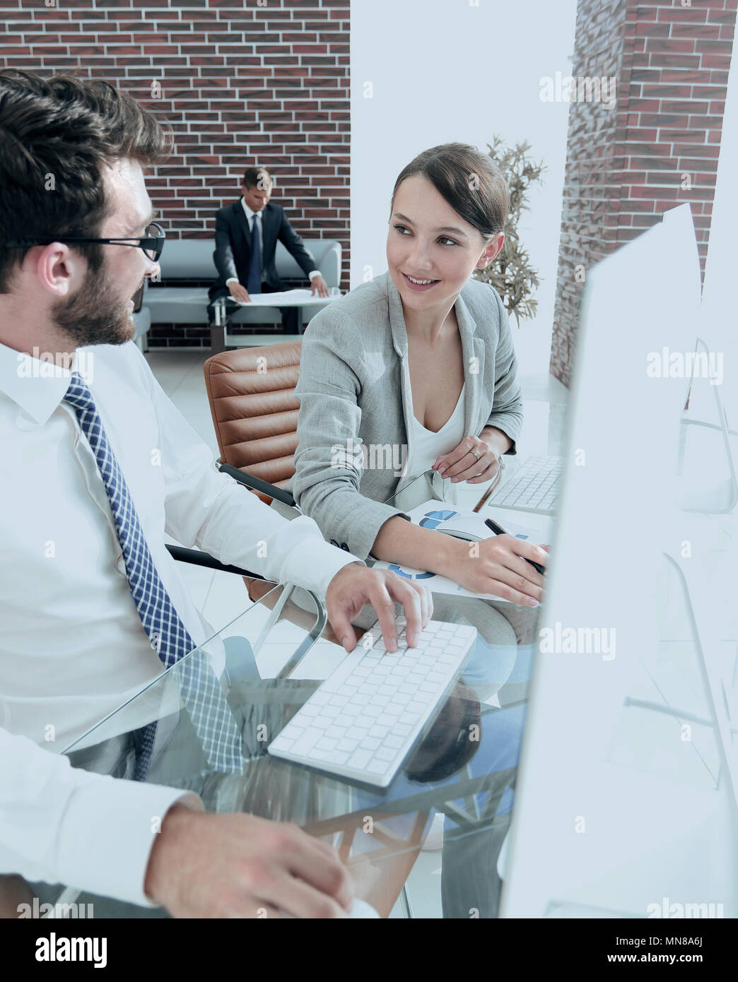 young professionals sitting behind a Desk Stock Photo - Alamy