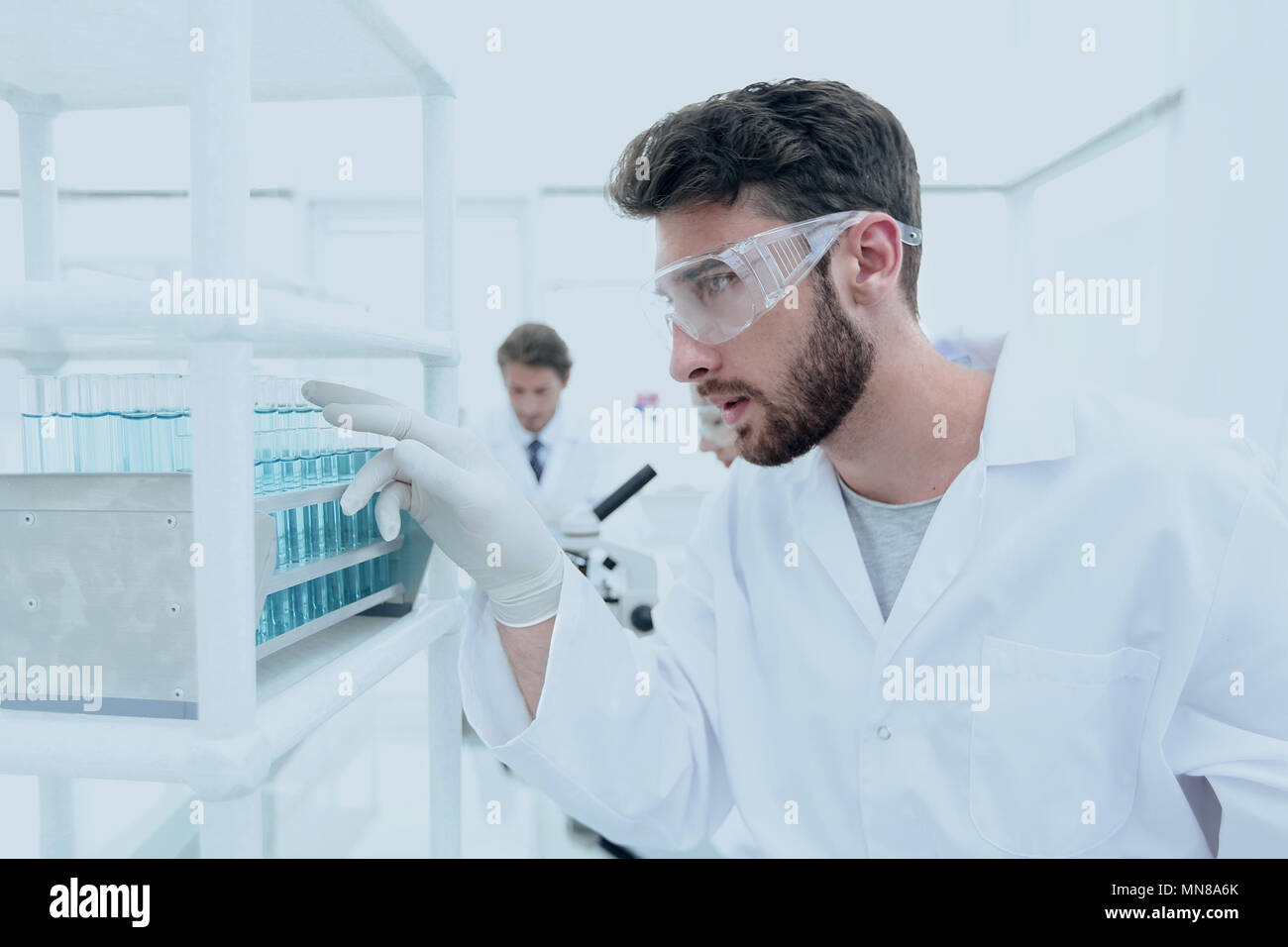 A young man doing an experiment in a chemical laboratory Stock Photo ...