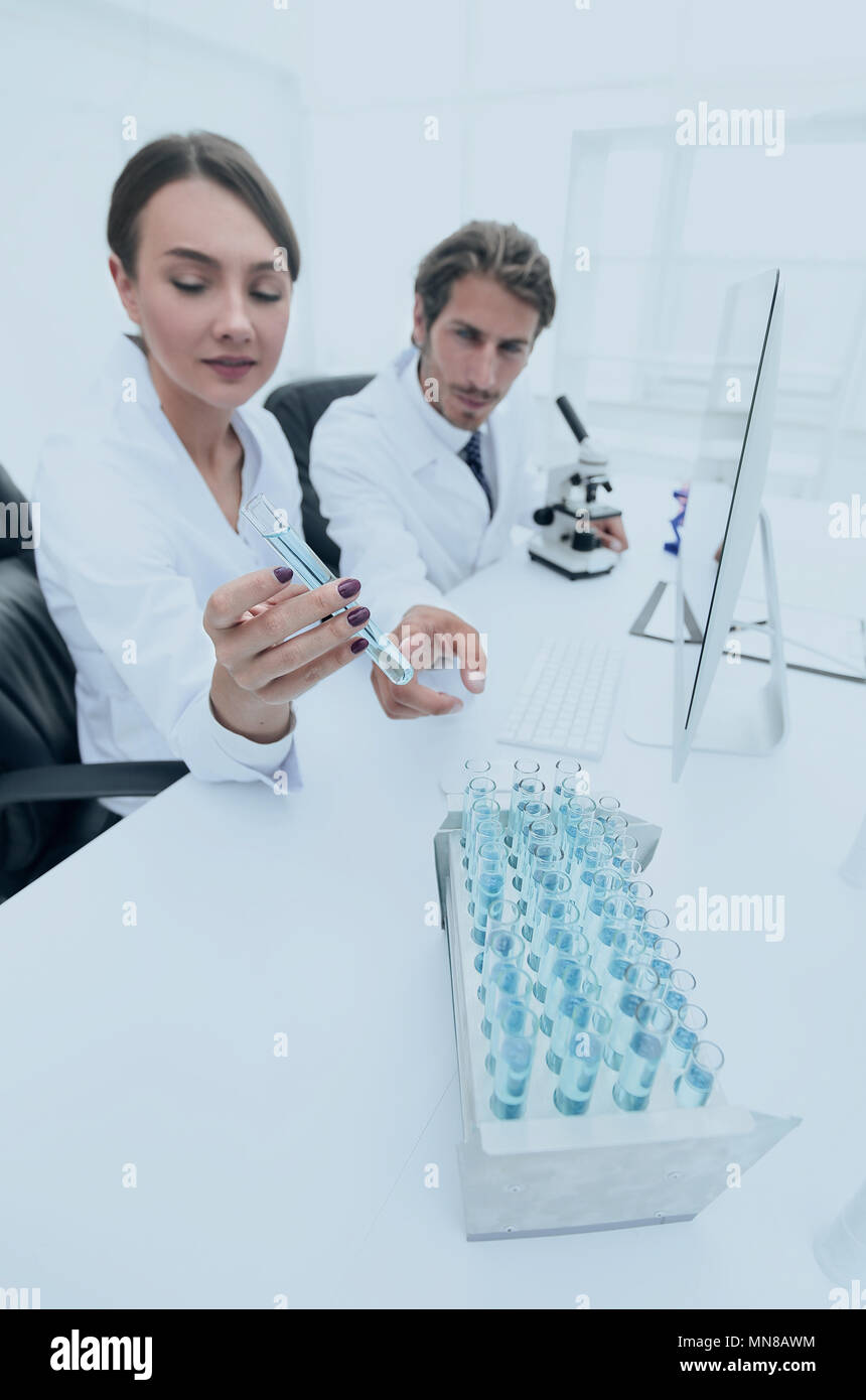 Woman looking at test tubes with colorful liquids Stock Photo - Alamy