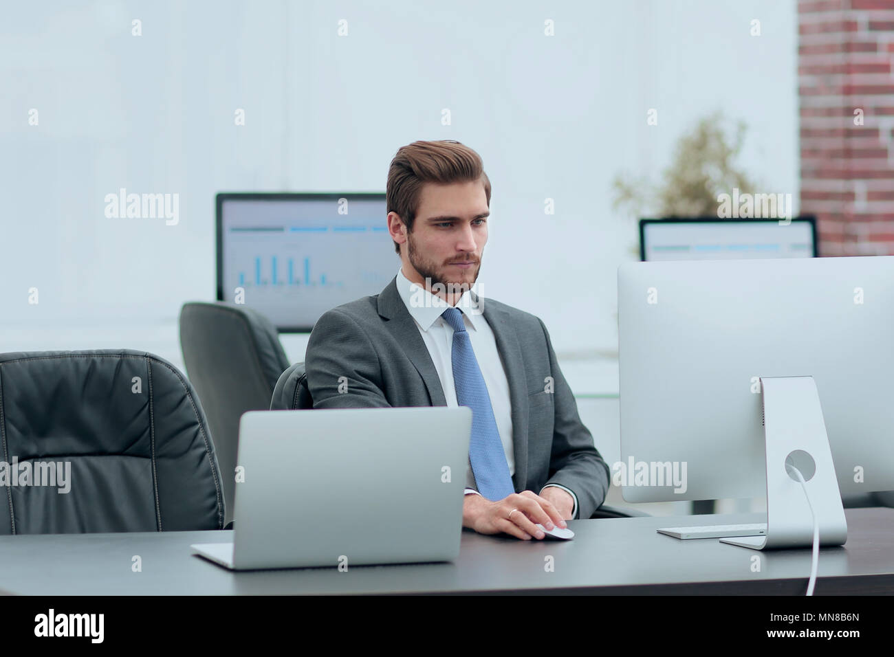 Young businessman using a computer on his desktop Stock Photo - Alamy