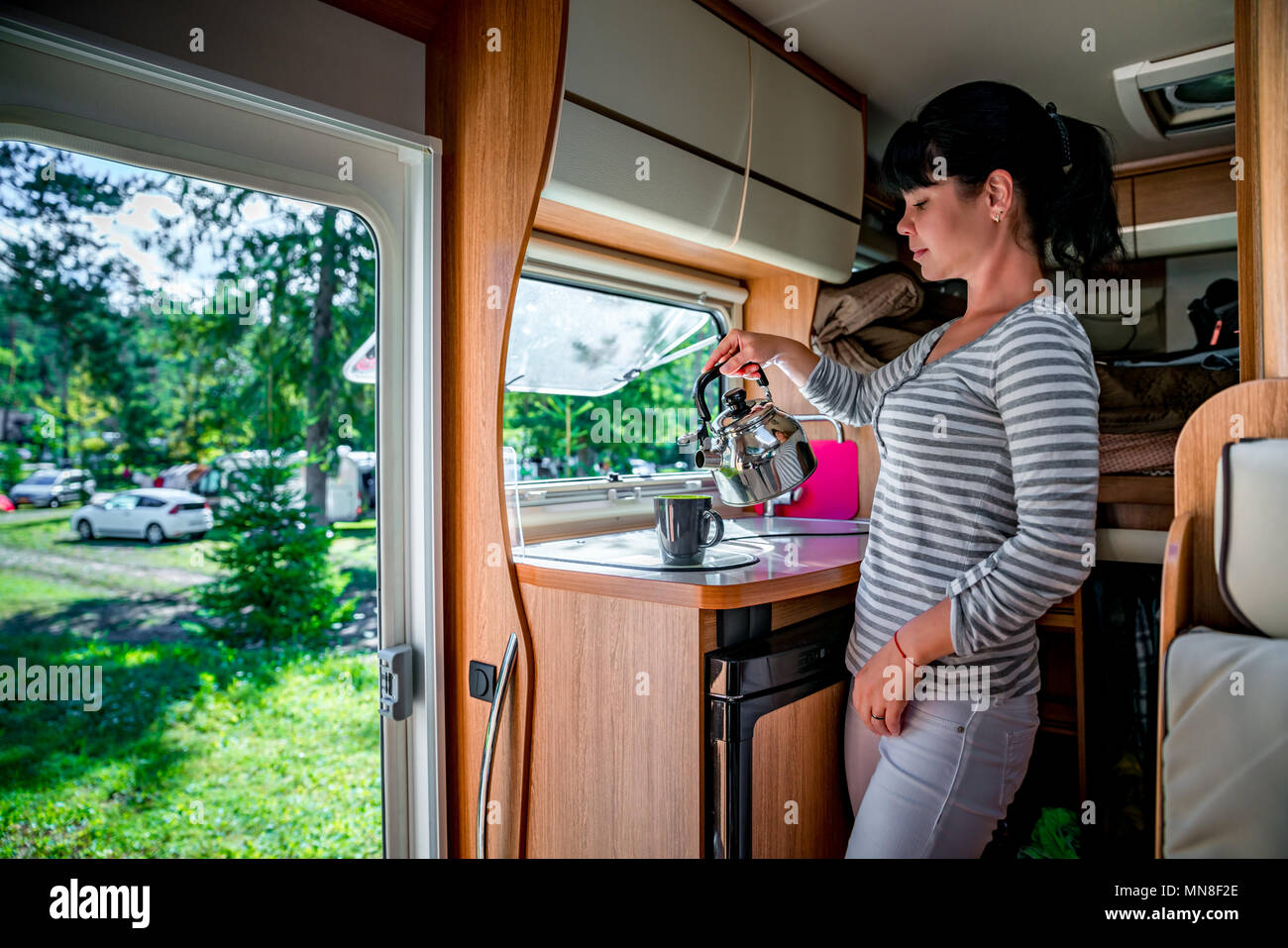 Woman cooking in camper, motorhome interior. Family vacation travel ...