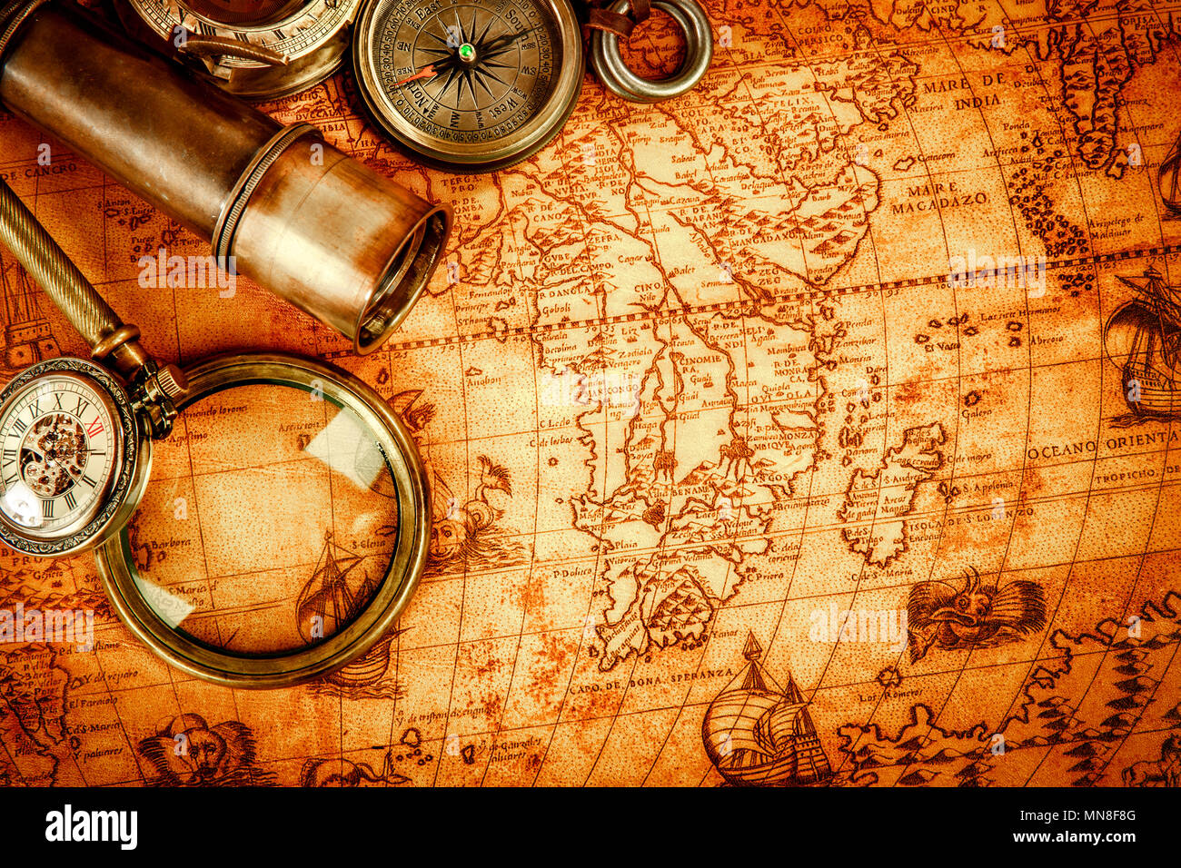 Vintage compass, magnifying glass, pocket watch, quill pen on an old ...