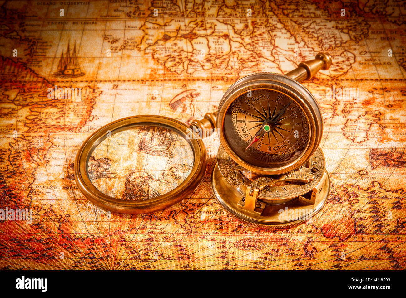 Vintage still life. Vintage compass lies on an ancient world map in ...