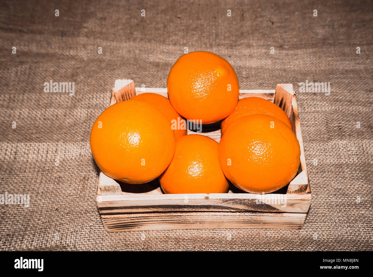 Fresh ripe orange fruits in old burnt wooden crate or box with ...