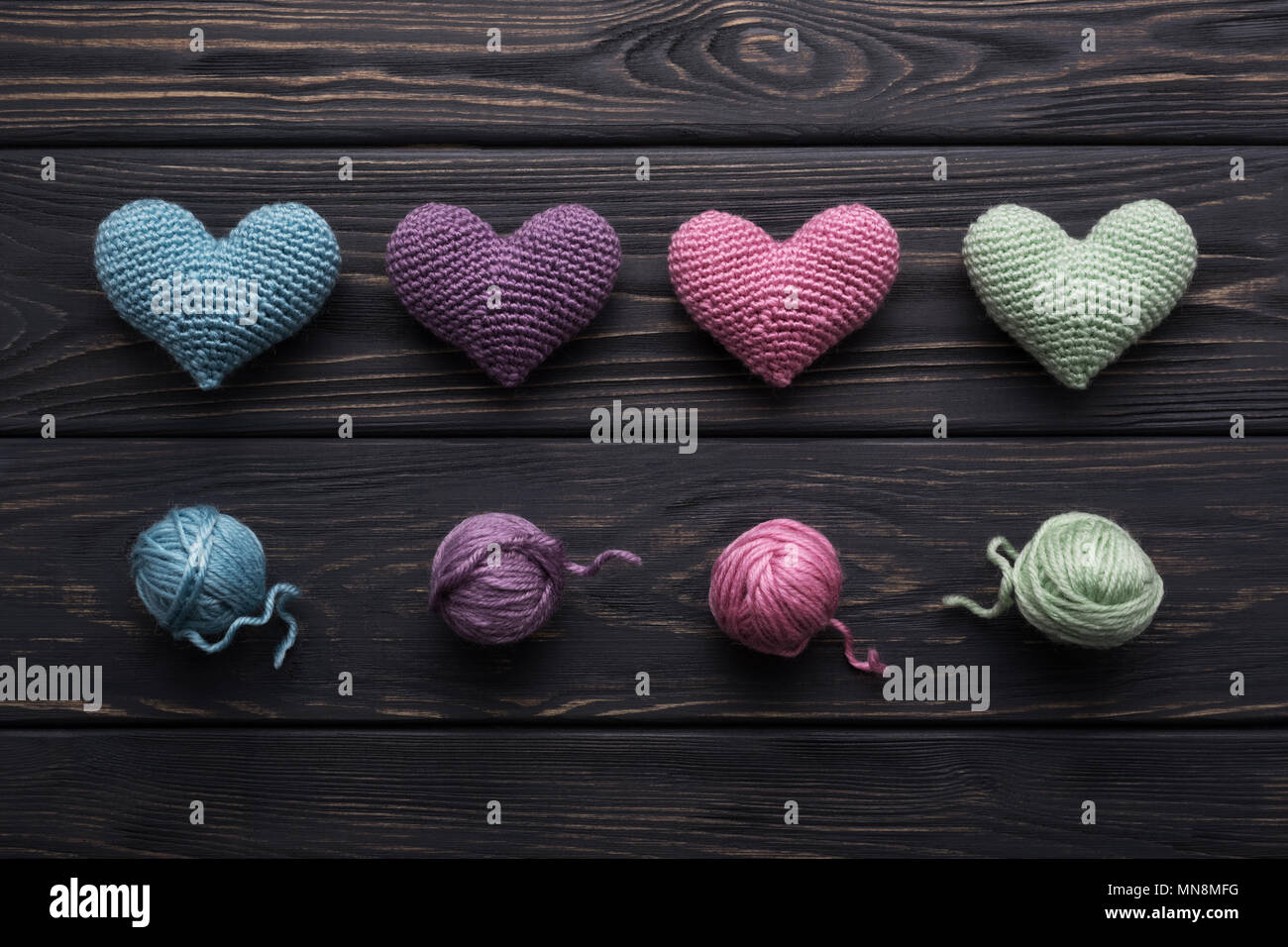 Colorful handicraft crocheted hearts & skeins of yarn on old gray ...