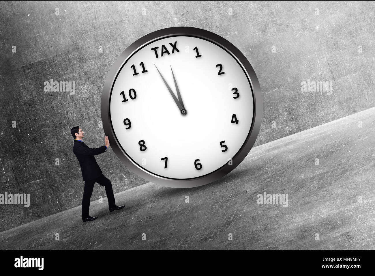 Attractive asian businessman pushing a clock with Tax deadline ...